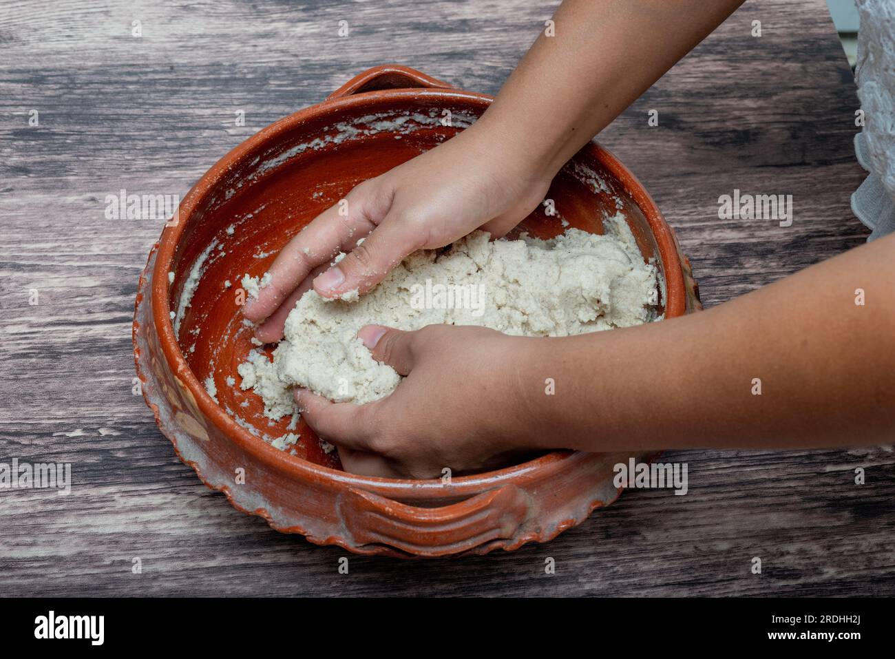 Woman's hands mixing corn dough to make tortillas. Mexican basic food ...