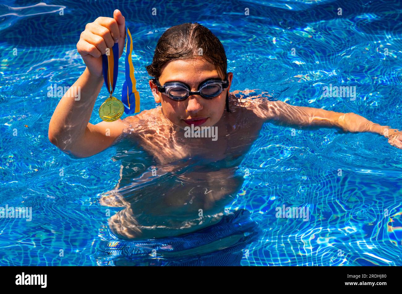 Successful caucasian young swimmer with award in outdoor pool. Golden ...