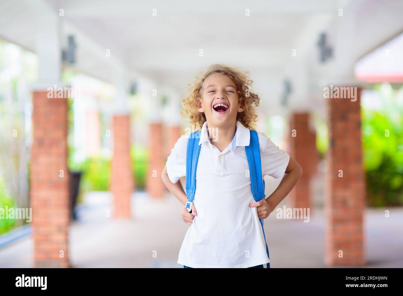 Kids go back to school. Happy little student with backpack and books on ...