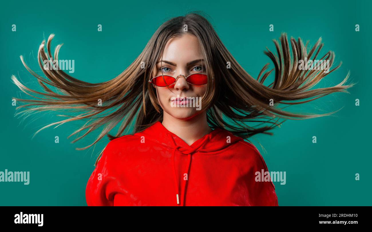 Portrait of woman with beautiful dancing hair on blue. Lady in red ...