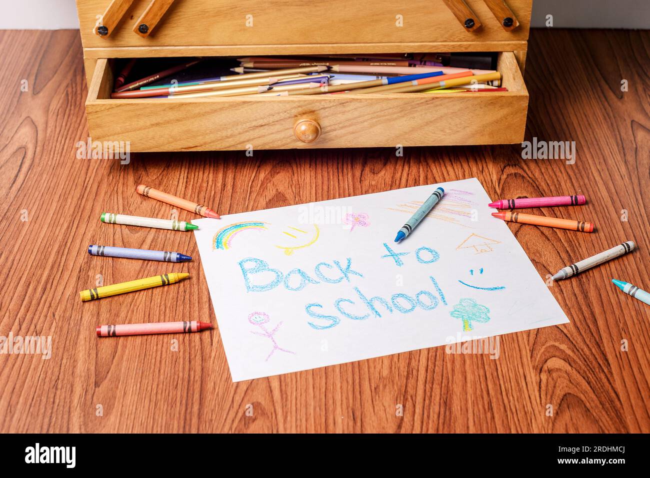 Colored pencils and crayons in disorder on a wood table. Group of ...