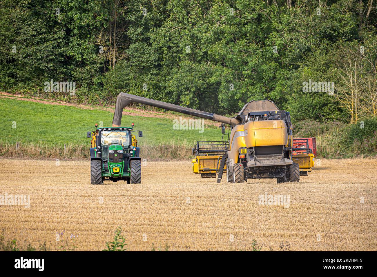 Farm machinery gathering a crop in a farmer's field Stock Photo - Alamy
