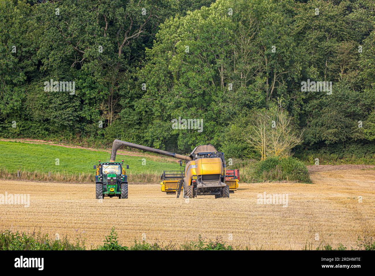 Farm machinery gathering a crop in a farmer's field Stock Photo - Alamy