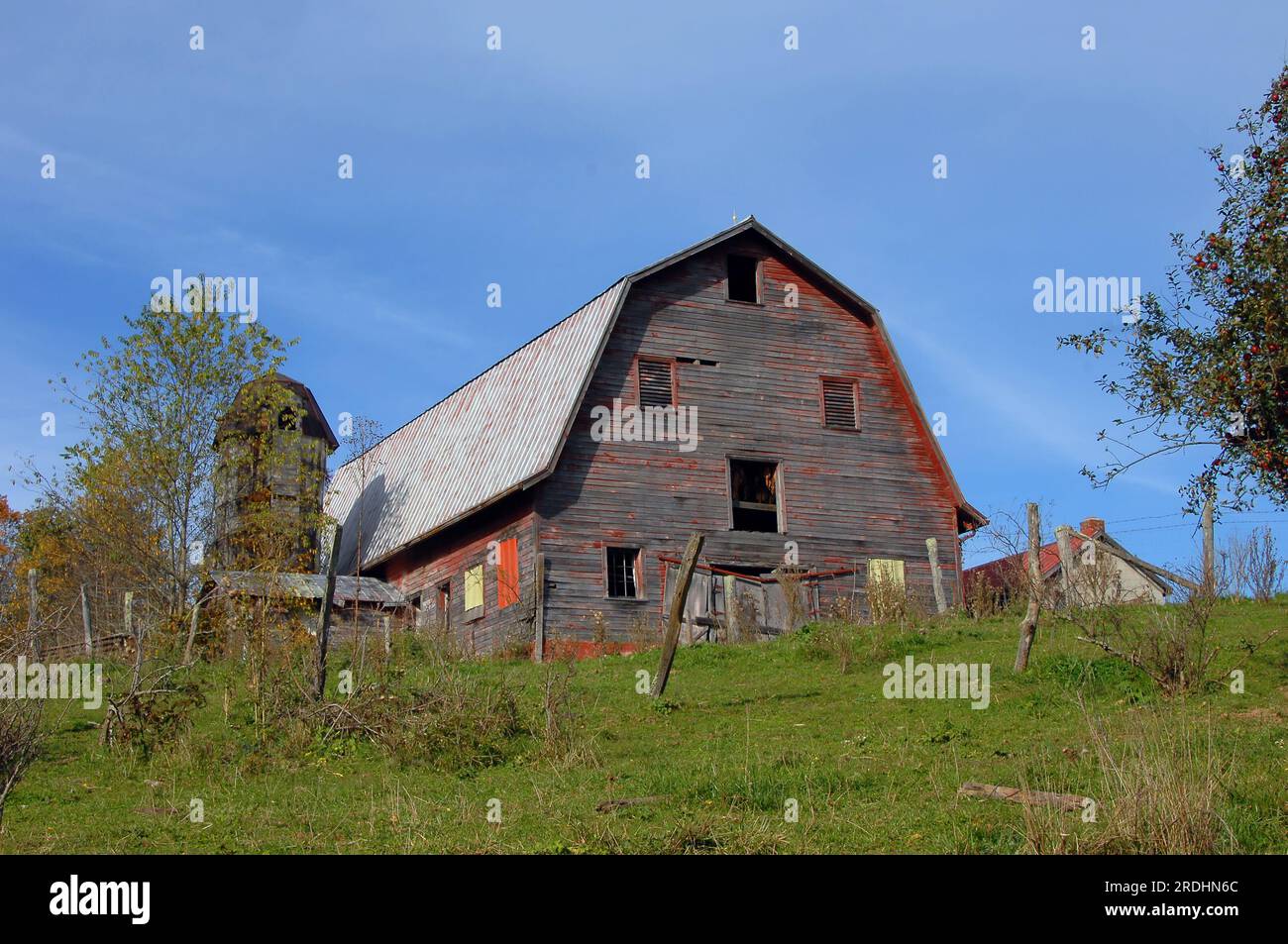 Topping a grassy hillside in rural Virginia, this rustic, red, wooden ...