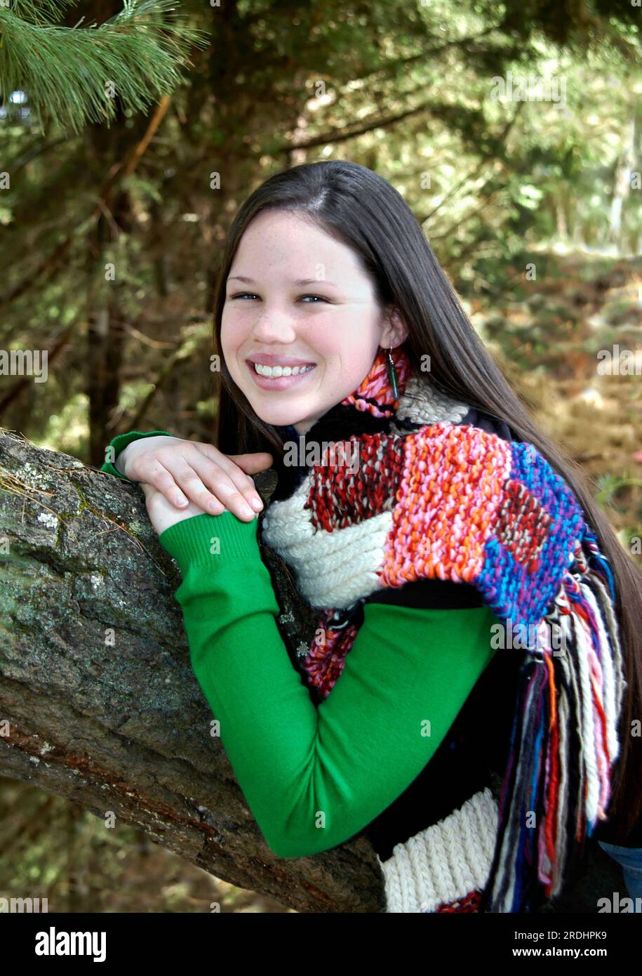 Glowing with happiness, this teenager poses leaning against a tree ...