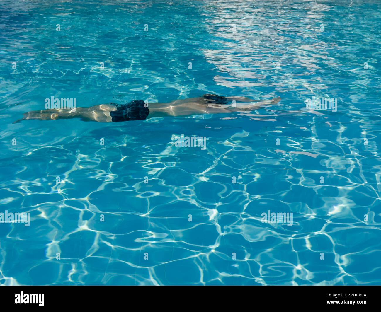 young boy swimming in the pool , moving under the water in the pool ...