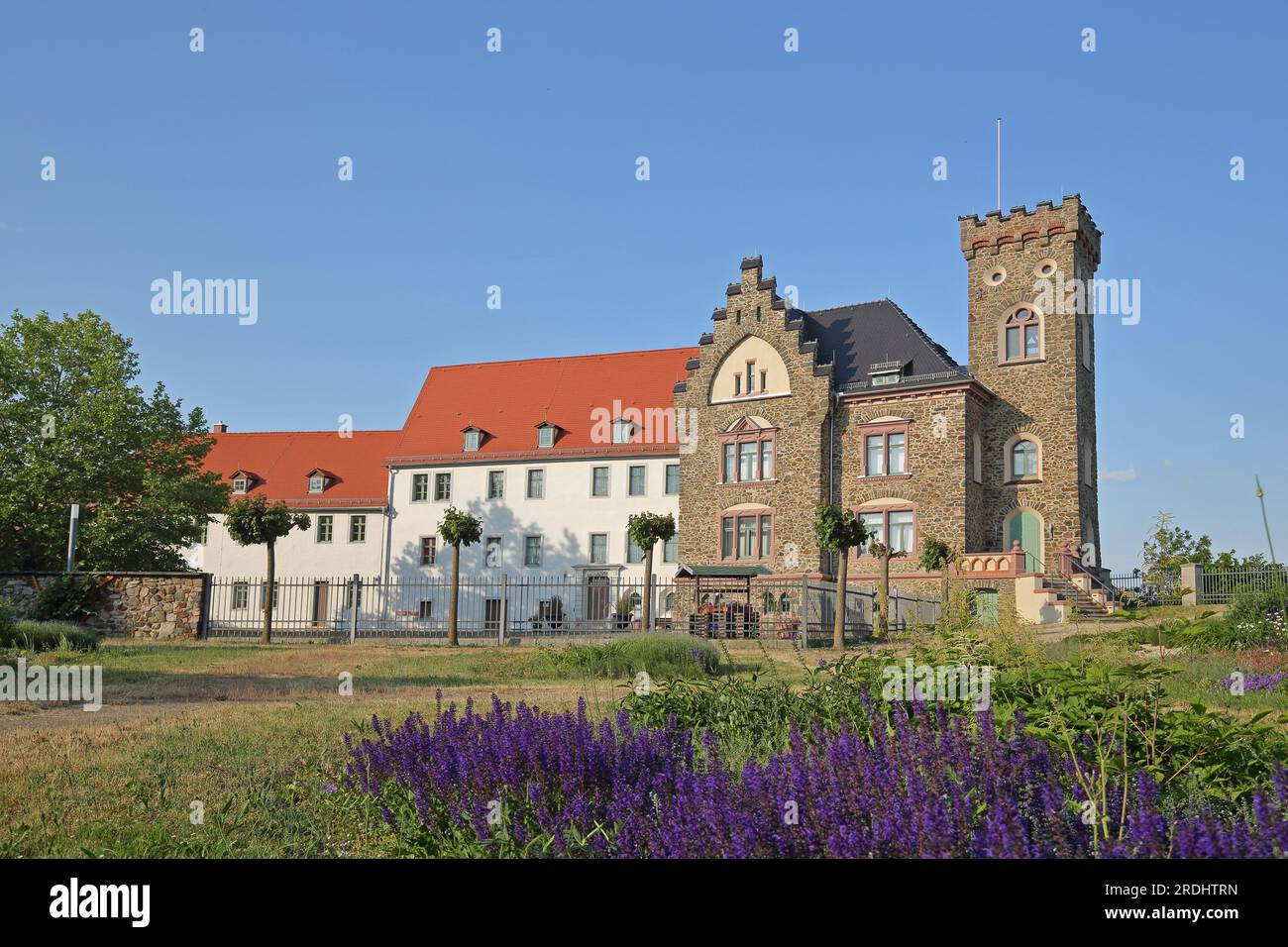Romanesque castle built around 12th century with tower and flower bed ...