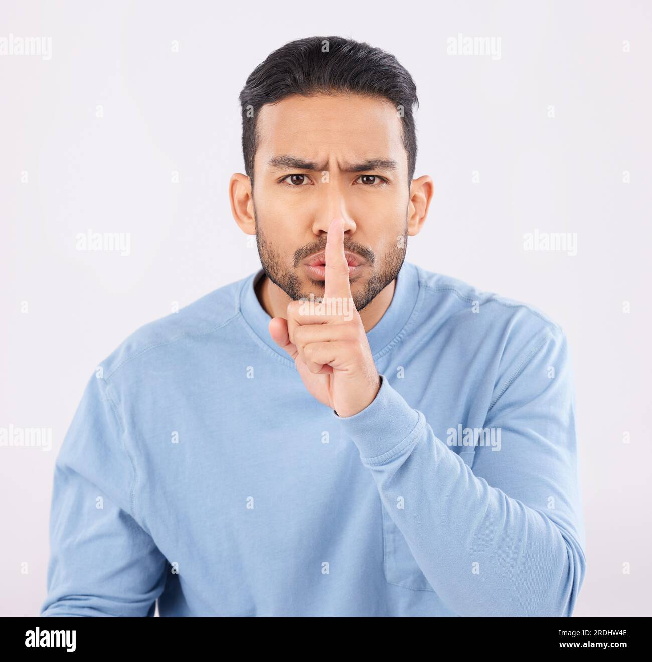 Whisper, portrait and angry asian man in studio with finger on lips ...