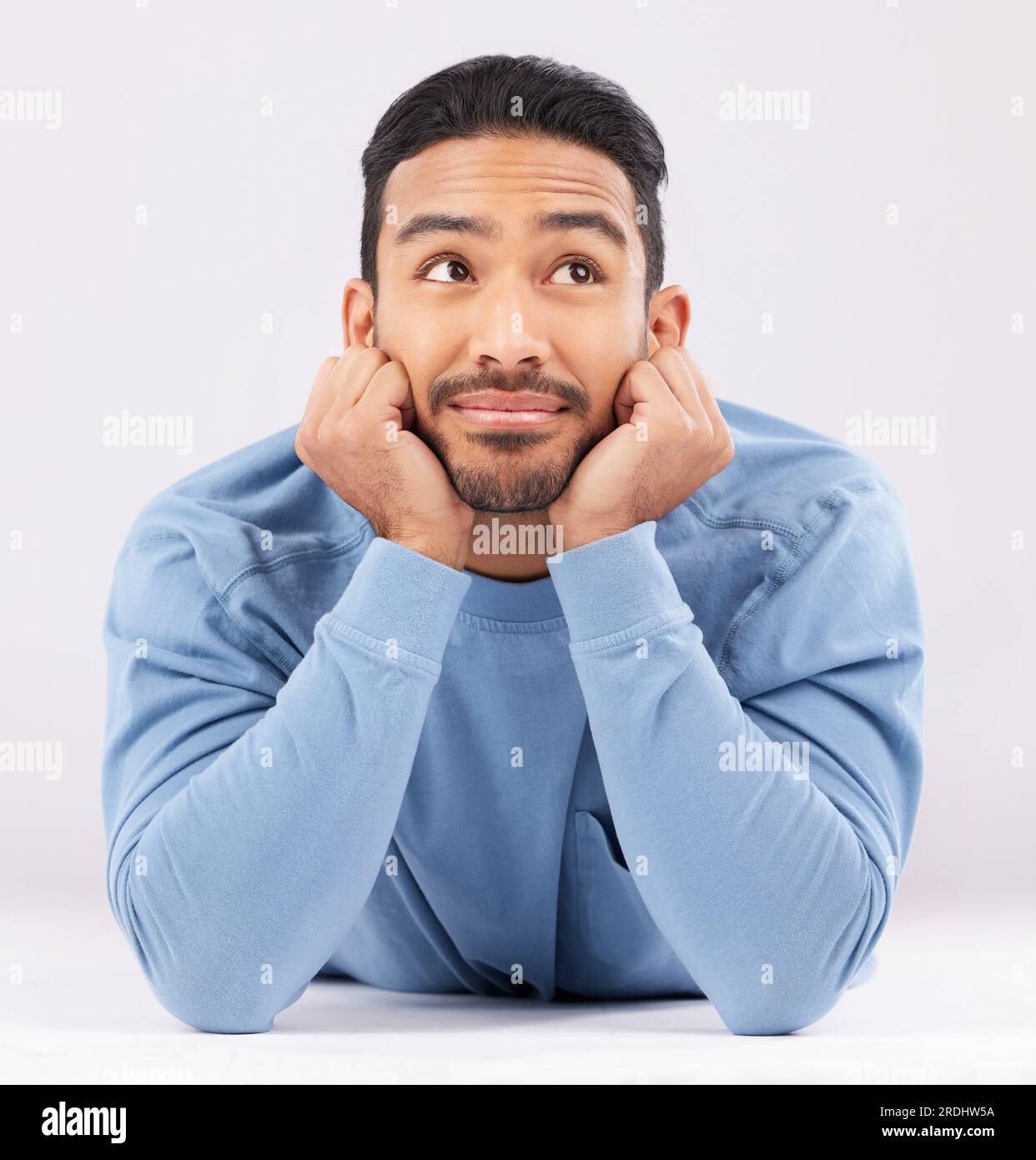 Memory, thinking and young man in a studio resting on his arms with a ...