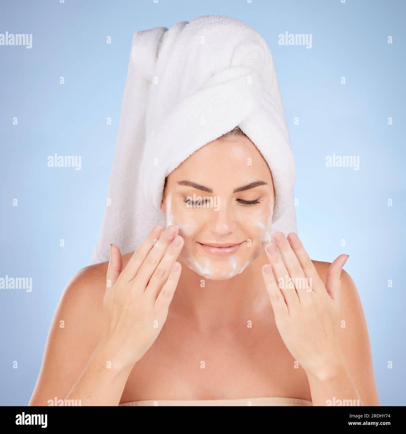 Shower, woman and washing face with foam in studio, blue background and ...