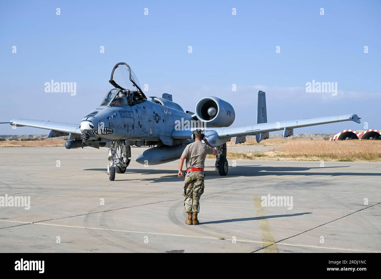 An armament team reloads an A-10 attack aircraft with rockets and 30mm ...