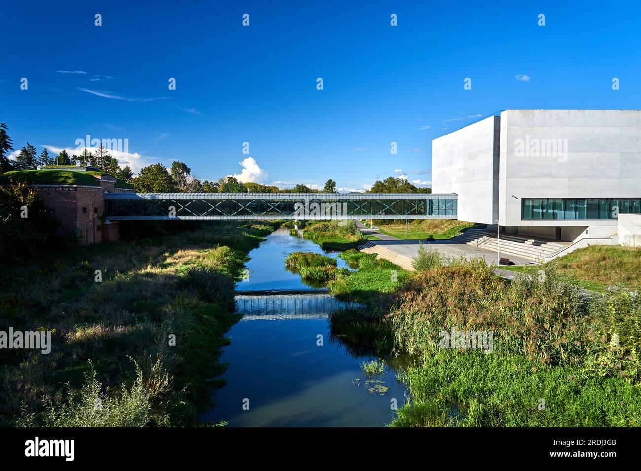 Historic fort building, footbridge and modern building on the Warta ...