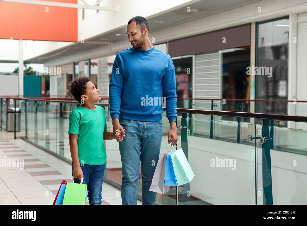 Family shopping. Happy father and son with colorful bags in mall Stock ...