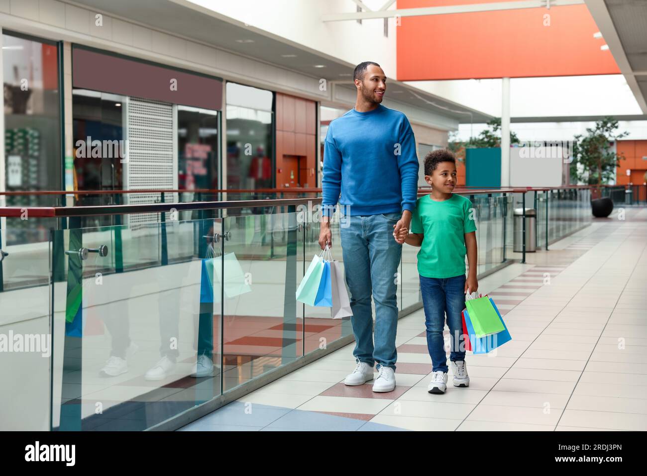 Family shopping. Happy father and son with colorful bags in mall Stock ...
