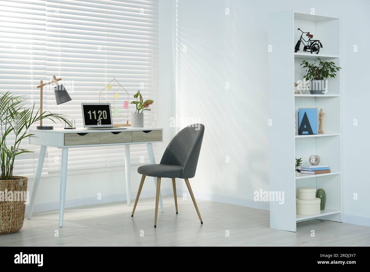 Cozy workspace with laptop, desk and comfortable chair at home. Stylish ...