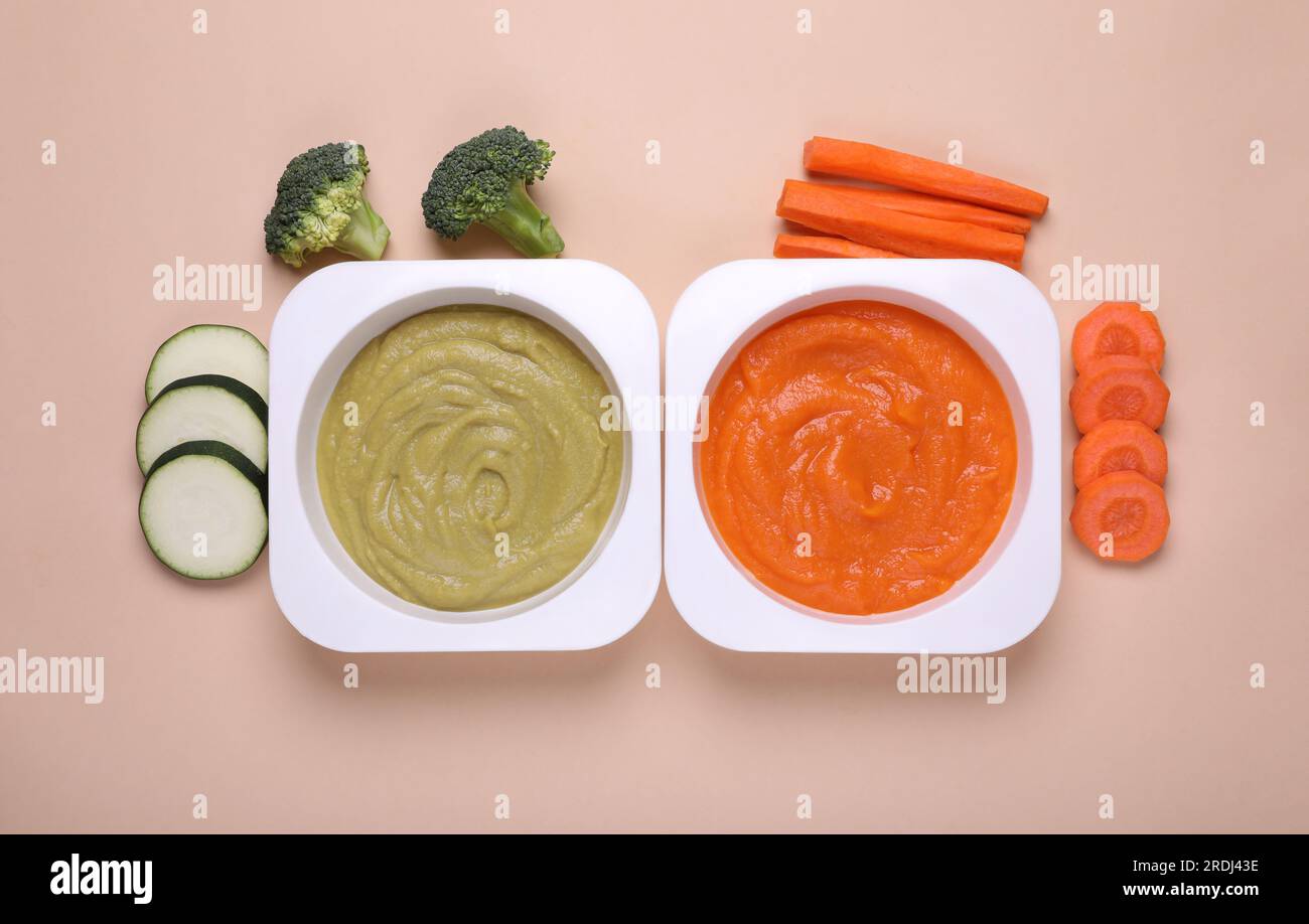 Bowls with healthy baby food and ingredients on beige background, flat ...