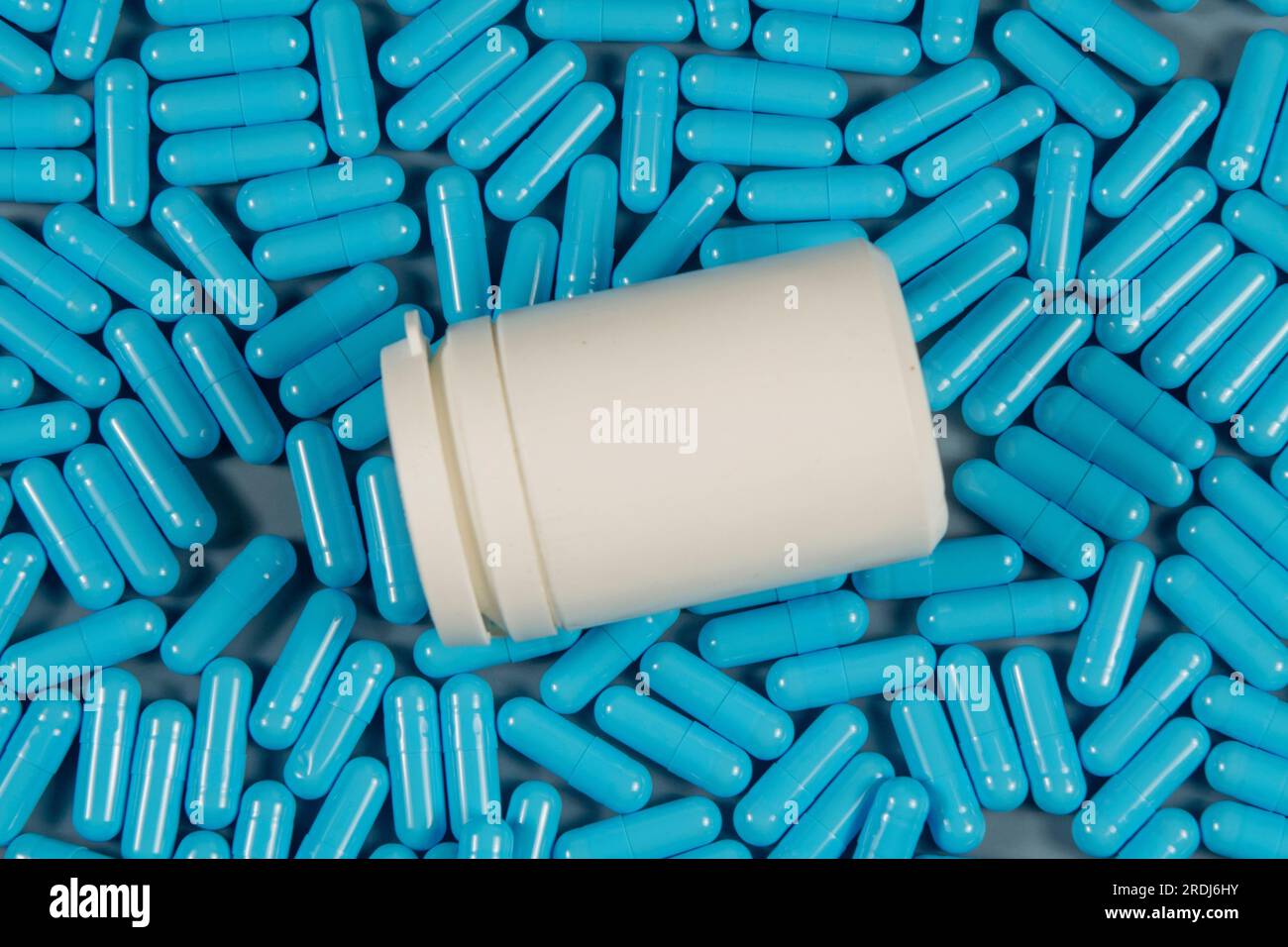 Blue antibiotic capsule pills texture with white bottle. Pharmaceutical ...