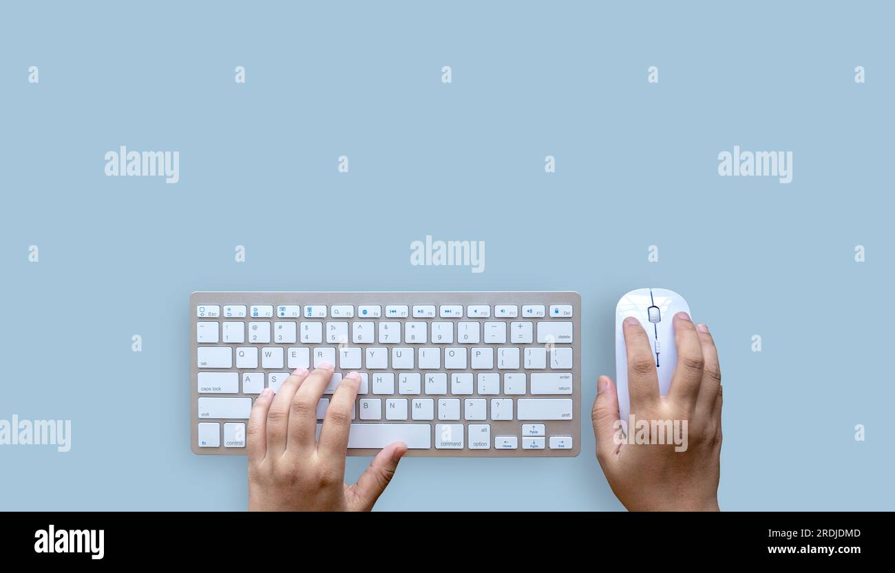 Person using computer from above. Office desktop. Blue background. Copy ...