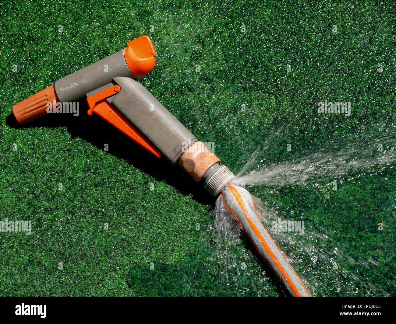 Leaking garden hose, splashing water Stock Photo - Alamy