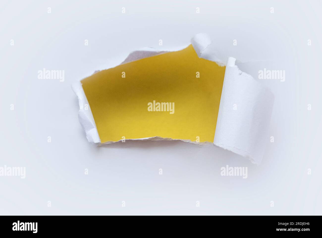 A hole of paper ripped and torn. Reveal a yellow wall behind. Backdrop ...