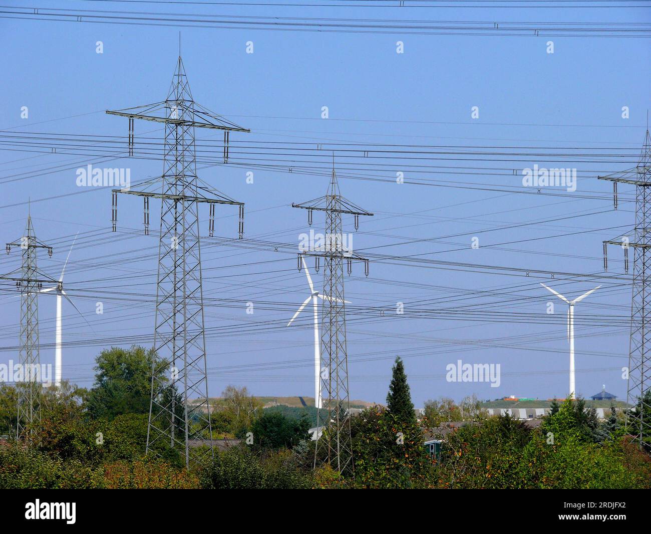 High-voltage pylons and wind turbines for power generation near ...