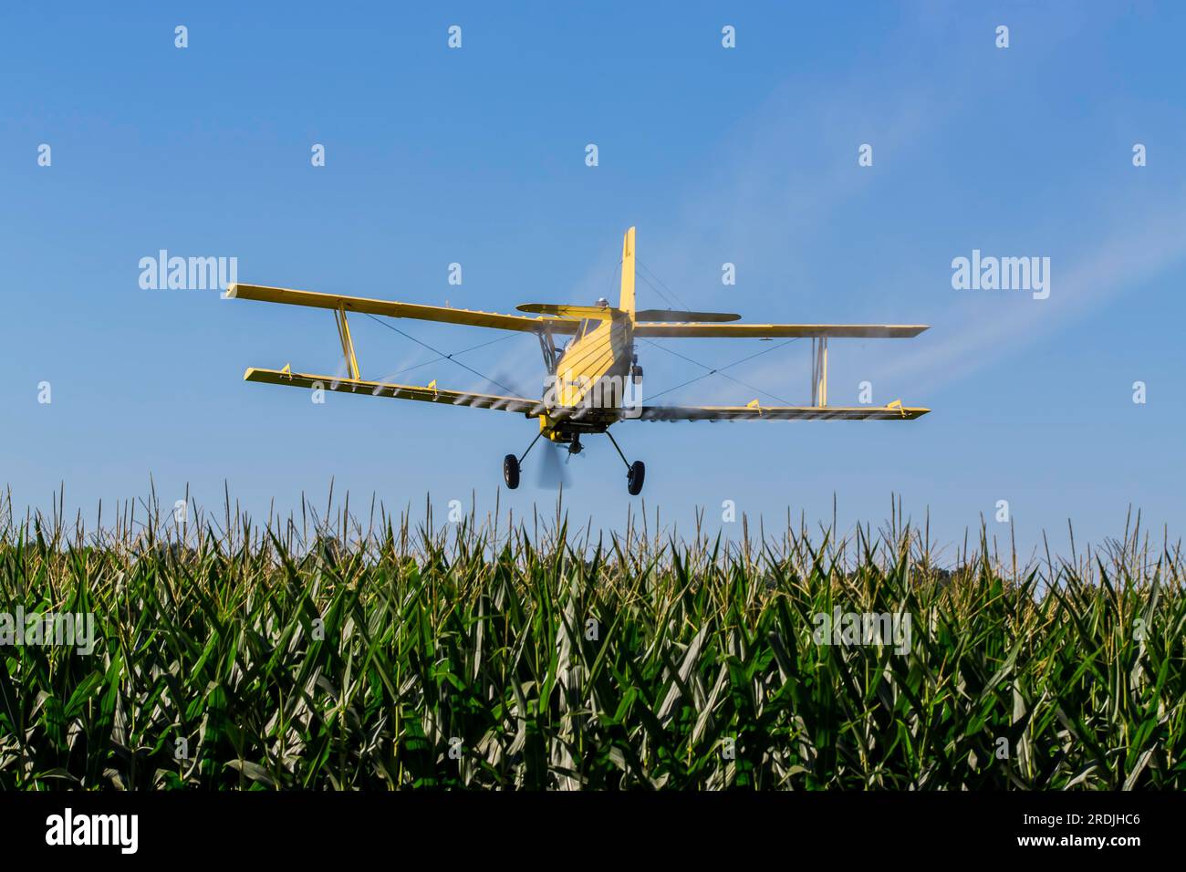 A crop duster applies chemicals to a field of vegetation Stock Photo ...