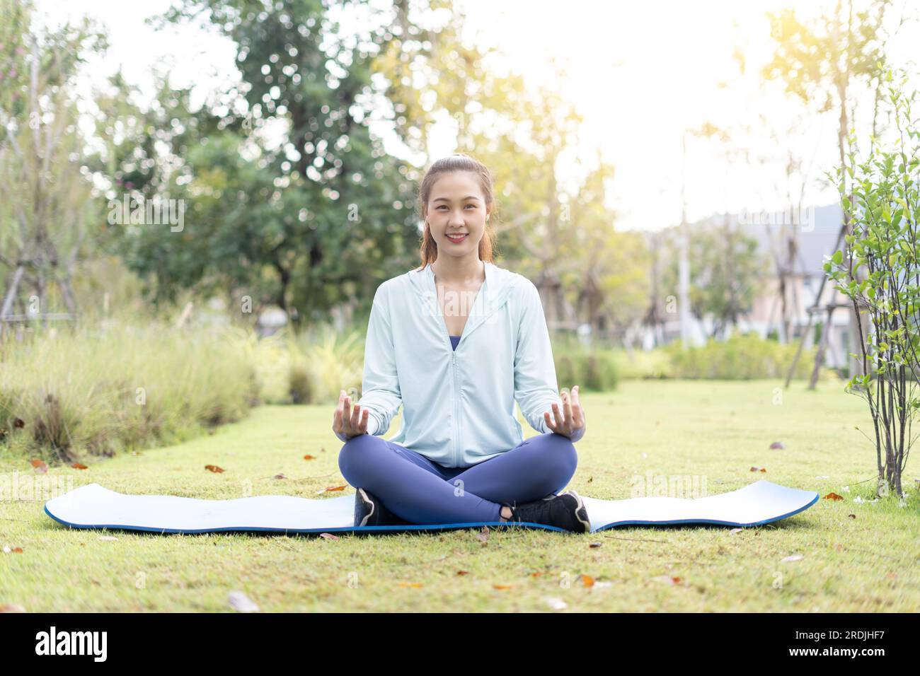 Asian woman doing lotus yoga position outside in the garden Stock Photo ...