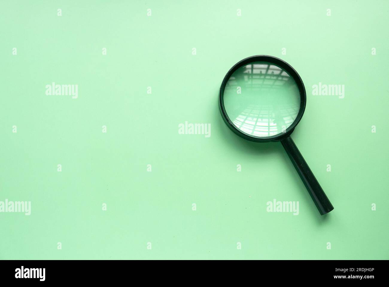 Magnifying glass over a green background. Copy space Stock Photo - Alamy