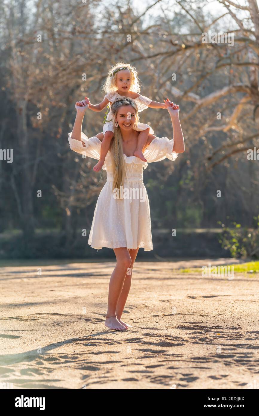 A beautiful young mother and her daughter enjoy the spring weather ...
