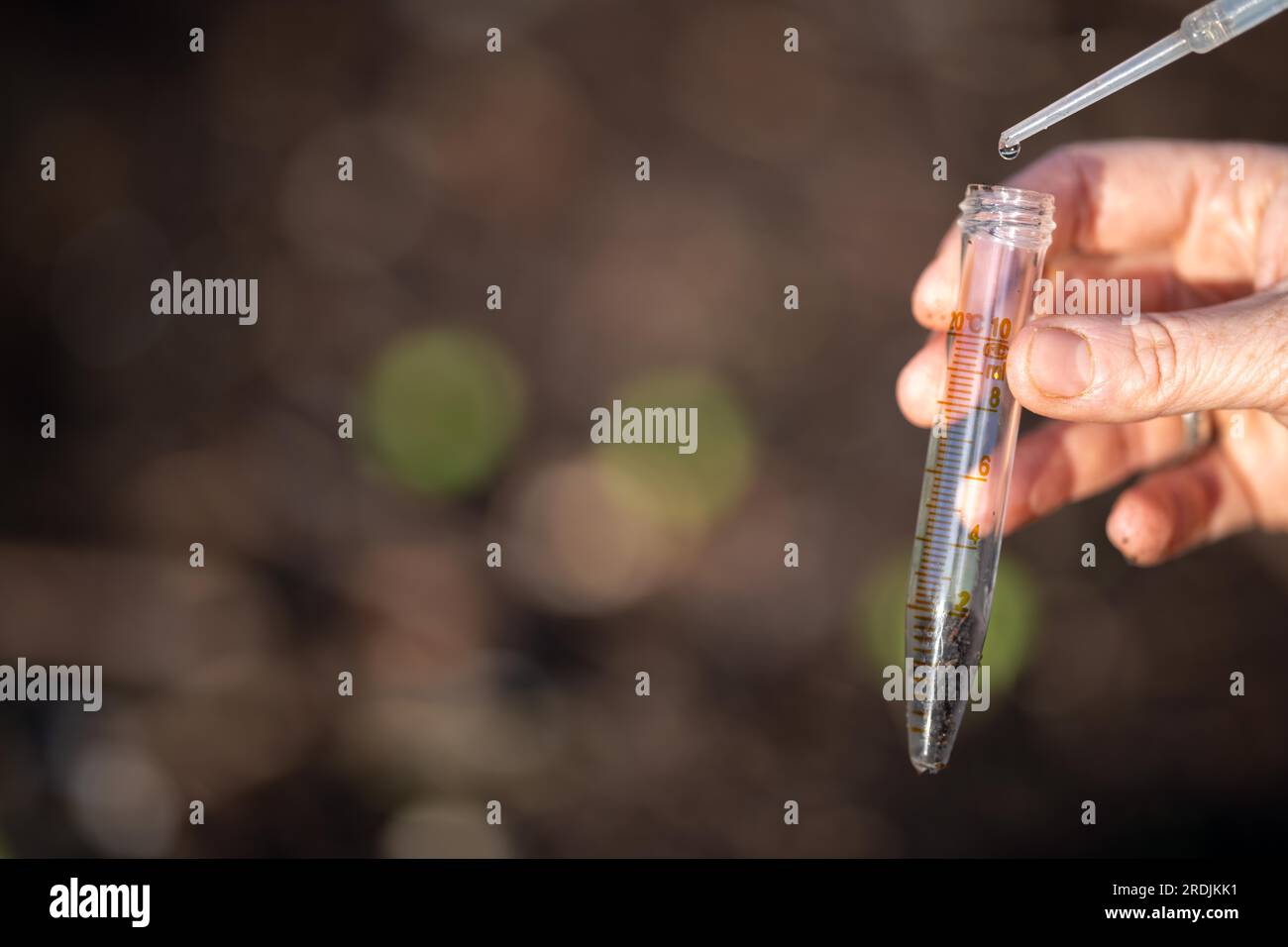 taking a soil sample for a soil test in a field. Testing carbon ...