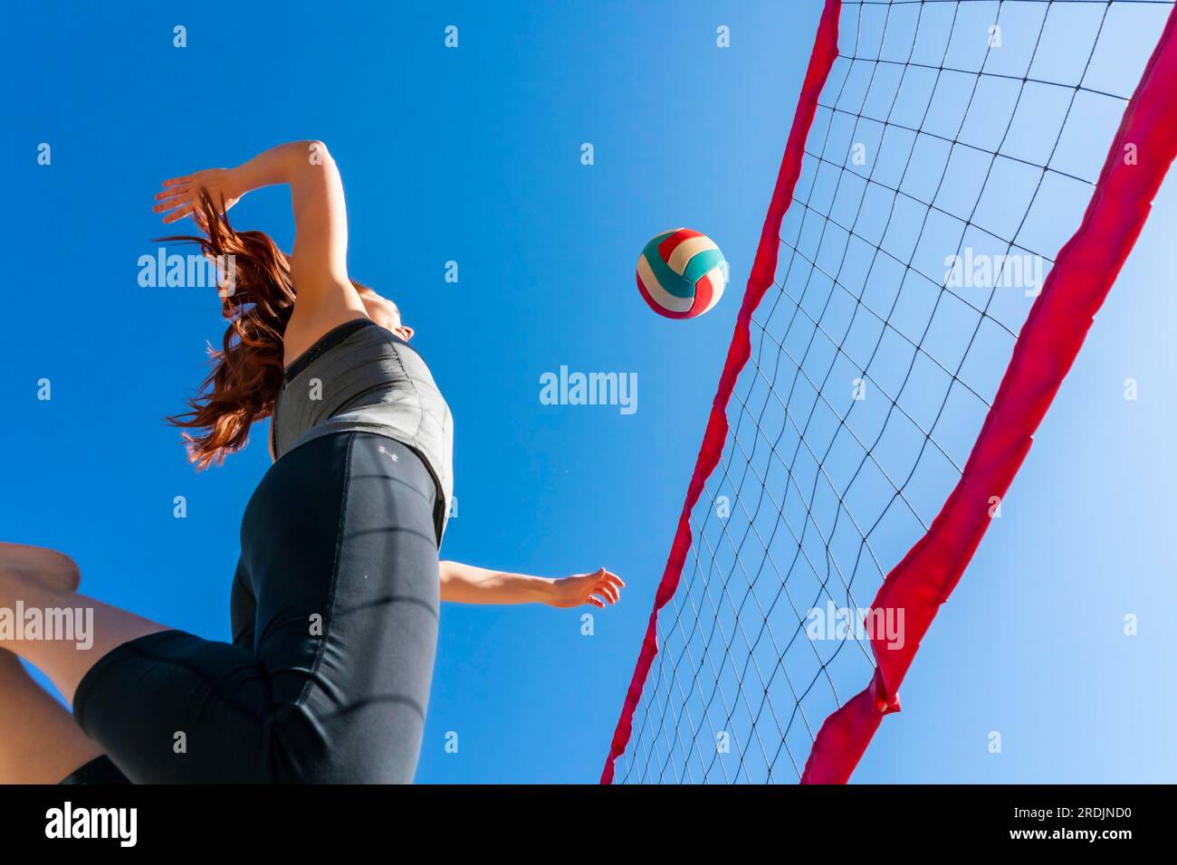 A redhead fitness model preparing to play volleyball Stock Photo - Alamy