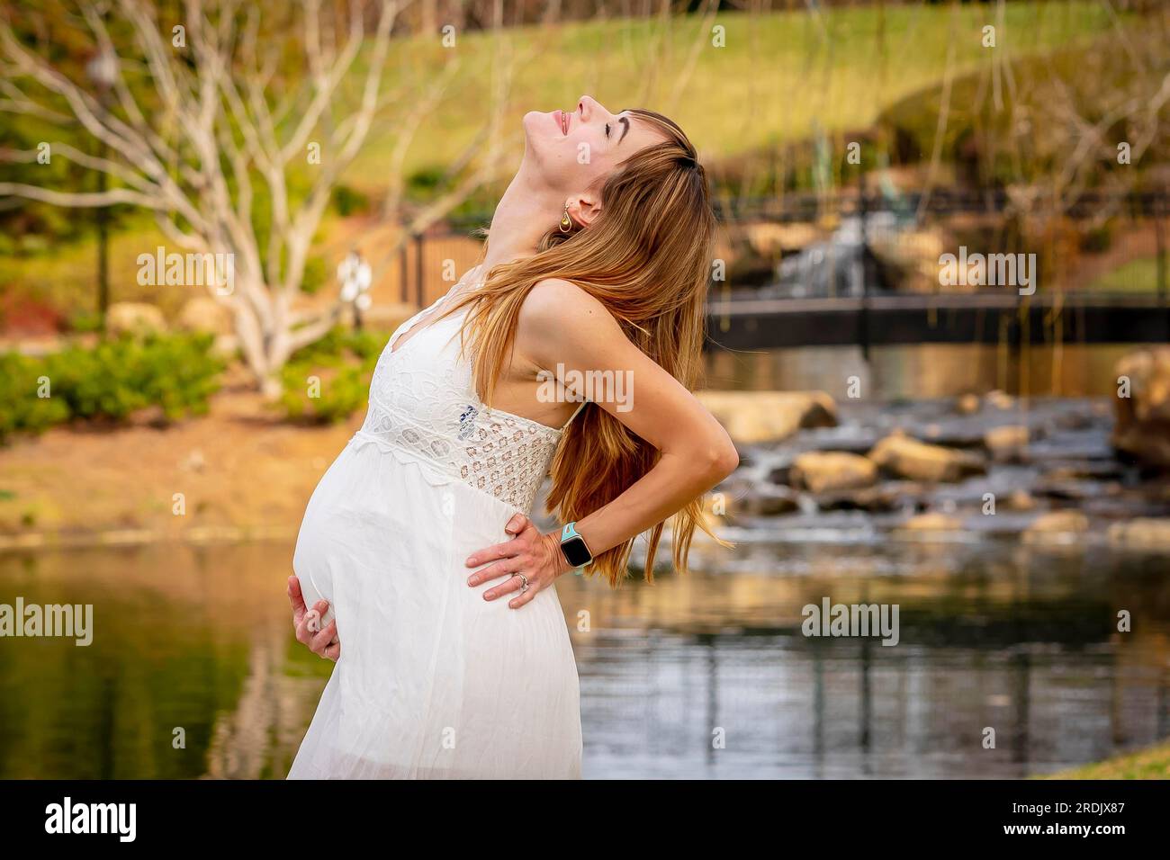 A beautiful expectant mother poses in an outdoor environment Stock ...