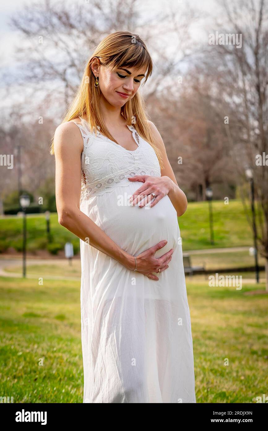 A beautiful expectant mother poses in an outdoor environment Stock ...
