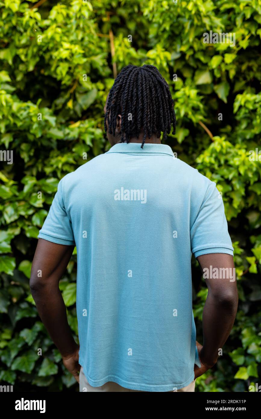 Rear view of african american man with dreadlocks wearing pale blue ...