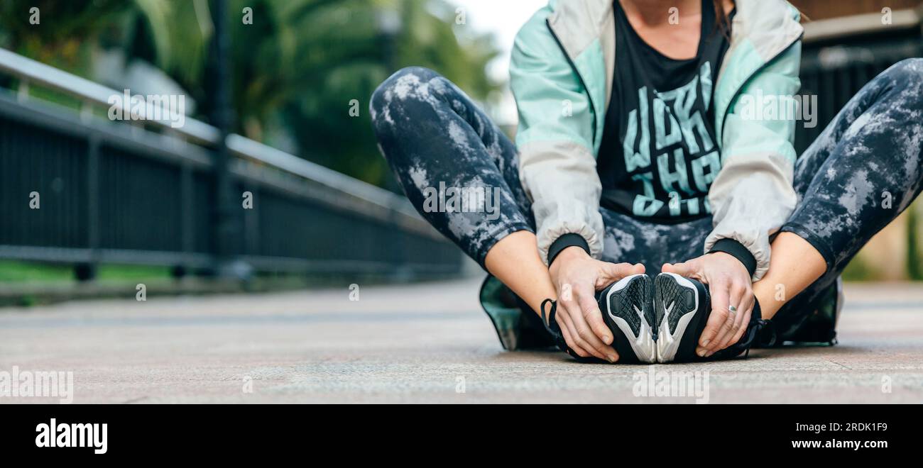 Woman runner relaxing sitting on the floor after training Stock Photo ...