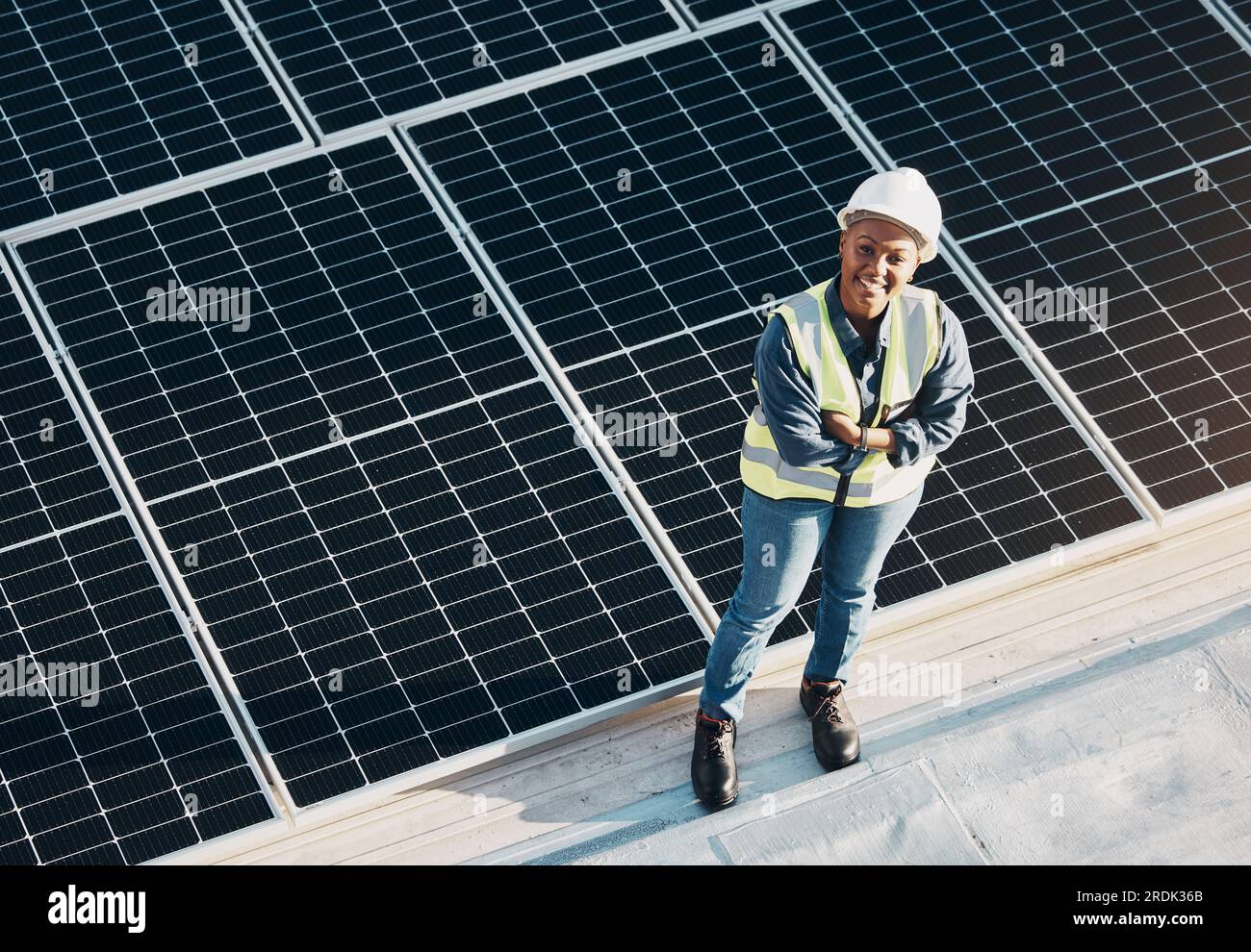 Woman, solar panel construction and arms crossed portrait with a smile ...