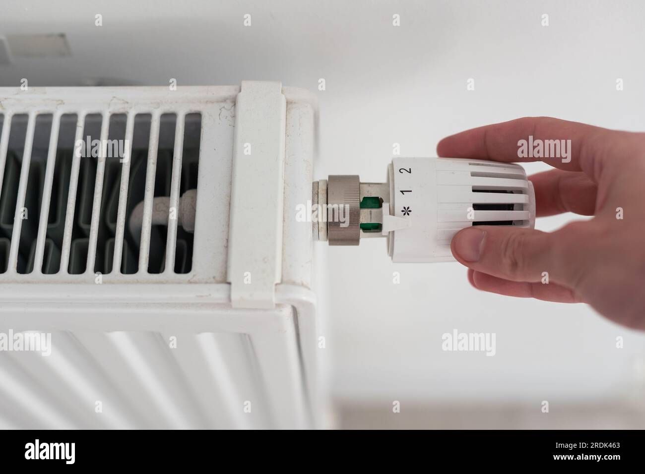 Building thermoregulation. The man turns the radiator knob Stock Photo ...