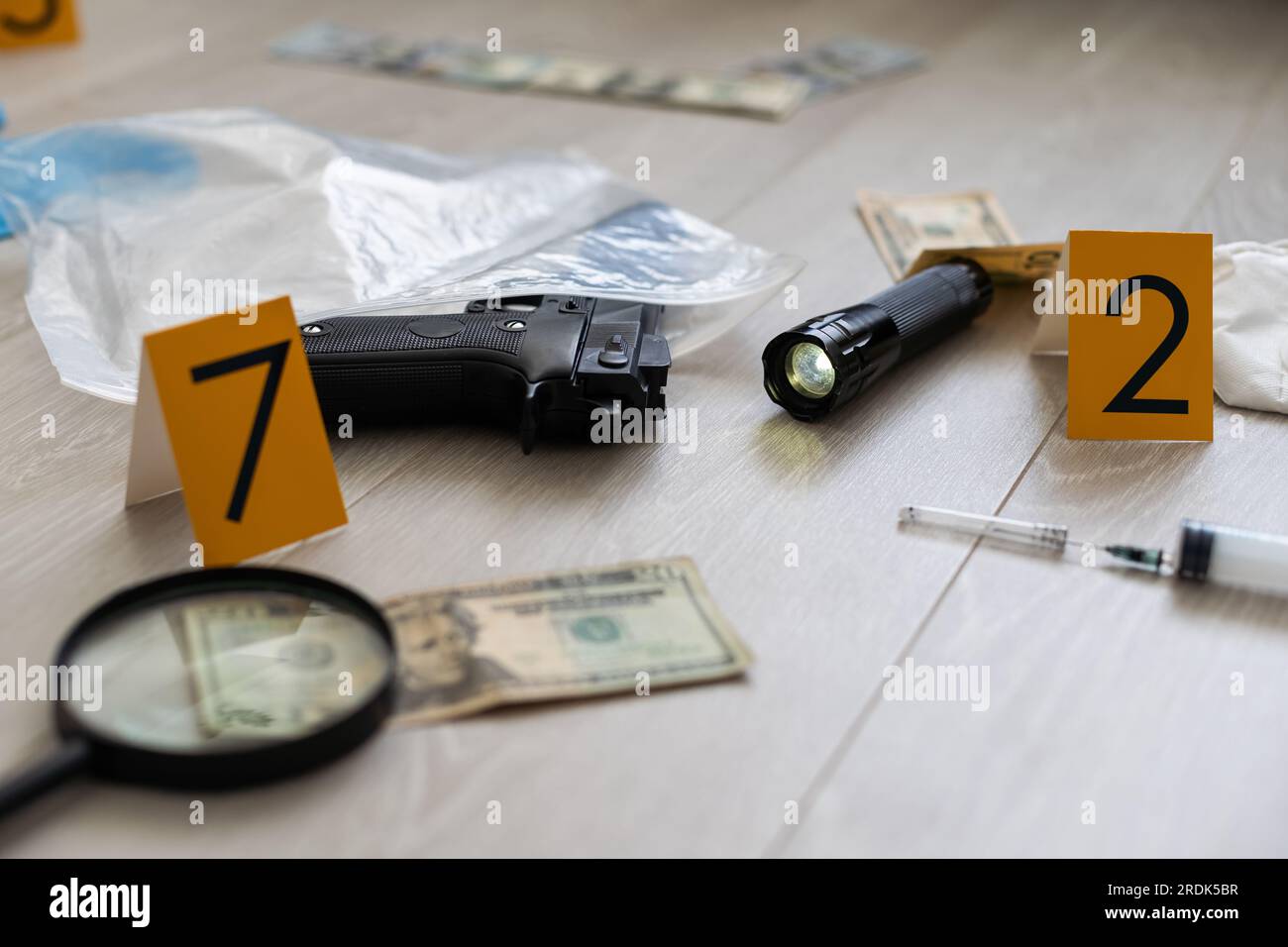 High contrast image of a crime scene with gun and markers on the floor ...