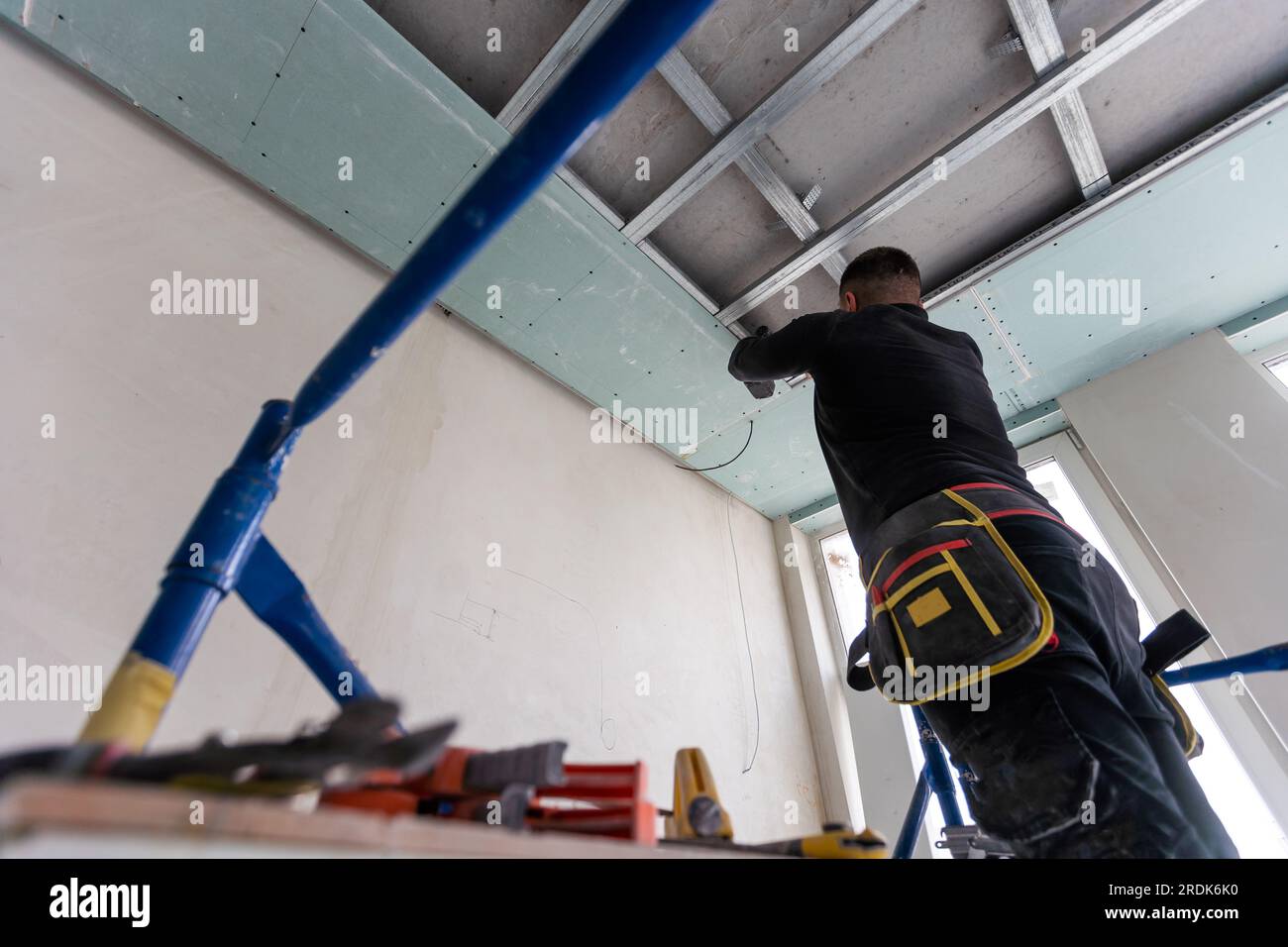 Workers fitting panel into frame of ceiling Stock Photo - Alamy