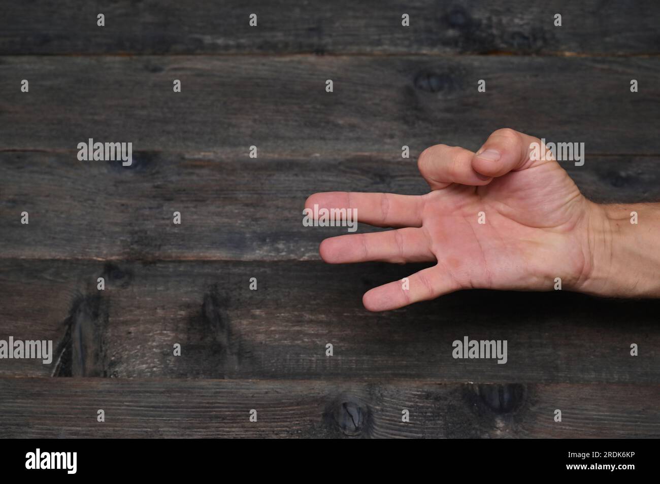 Hand of man showing fingers on wooden background counting number 3 ...