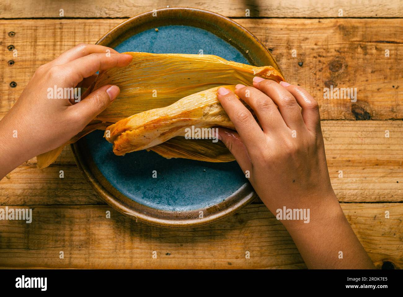 Person opening a tamale with his hands. Tamale, typical Mexican food ...