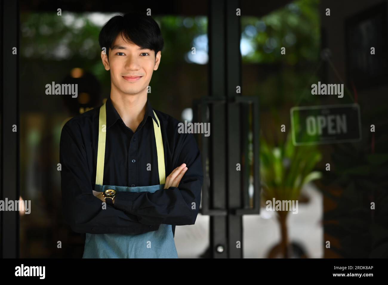 Successful small business owner wearing apron standing with crossed ...