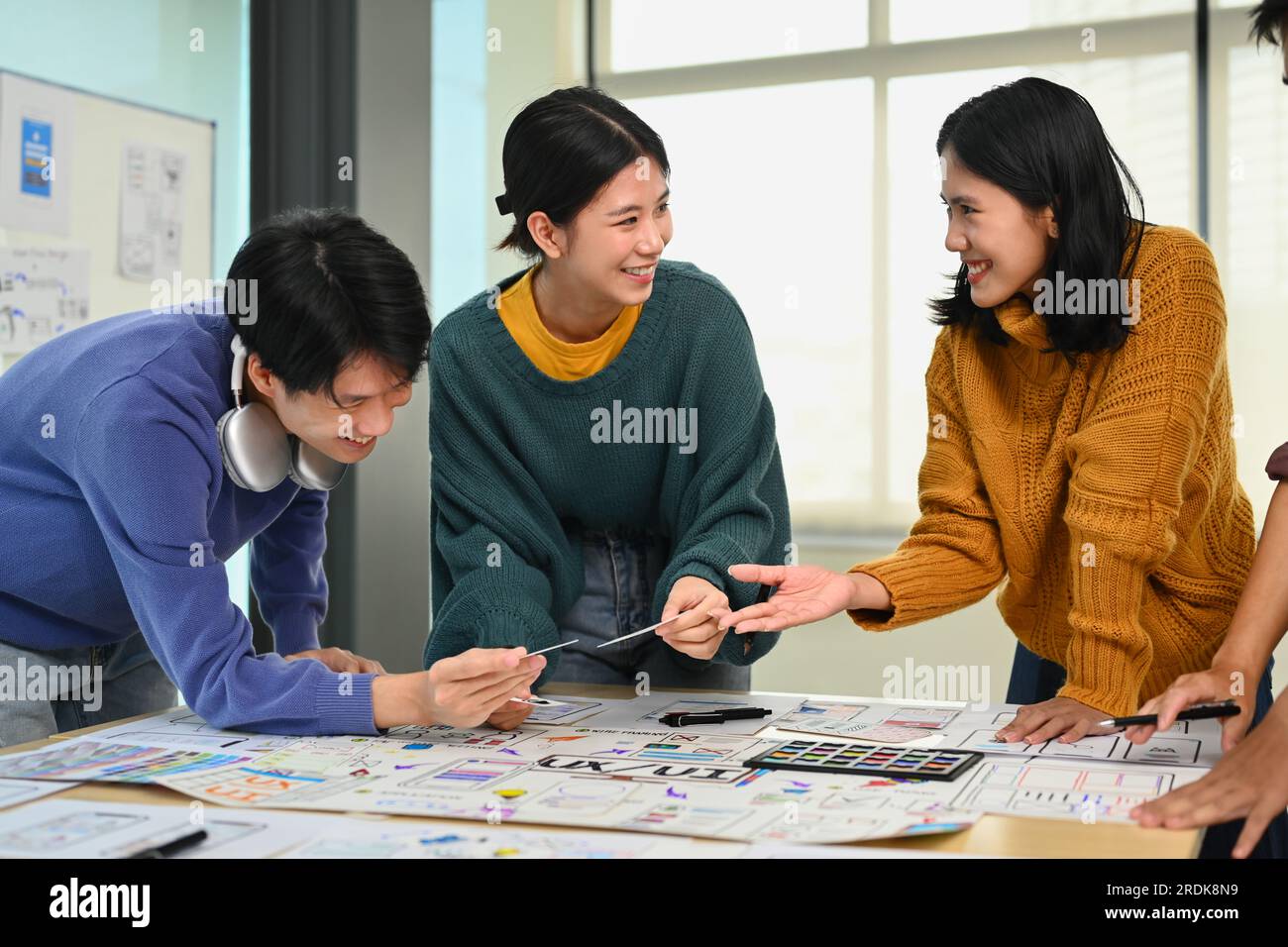 Happy Smiling Young Designers Brainstorming And Discussing New App Features At Co Working Space