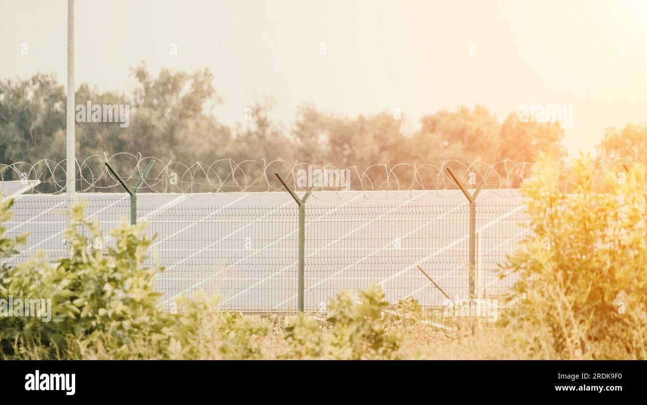 Large solar station with blue photovoltaic panels fenced with lattice ...