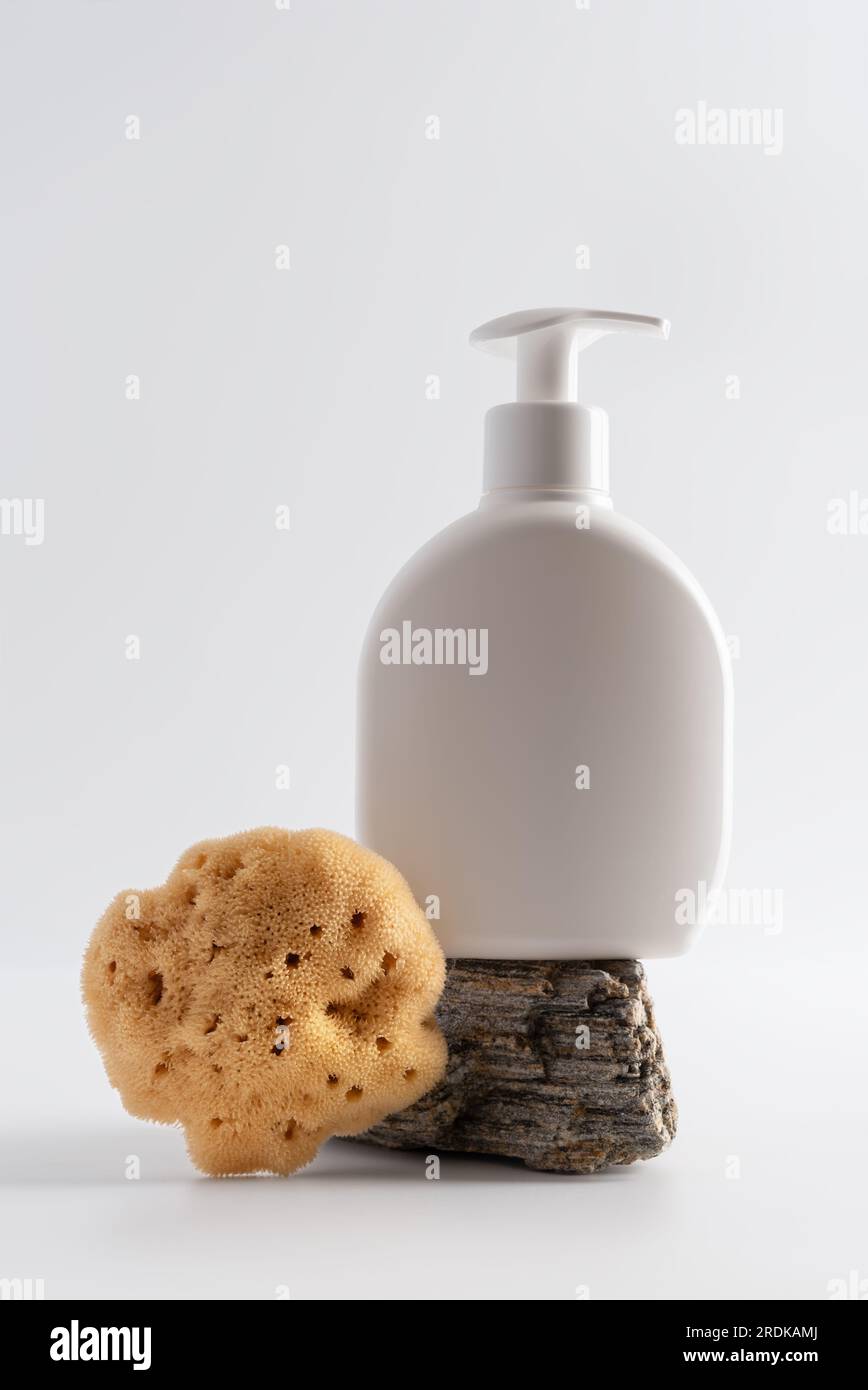 Mock up white plastic bottle and natural sea sponge on a stone podium ...