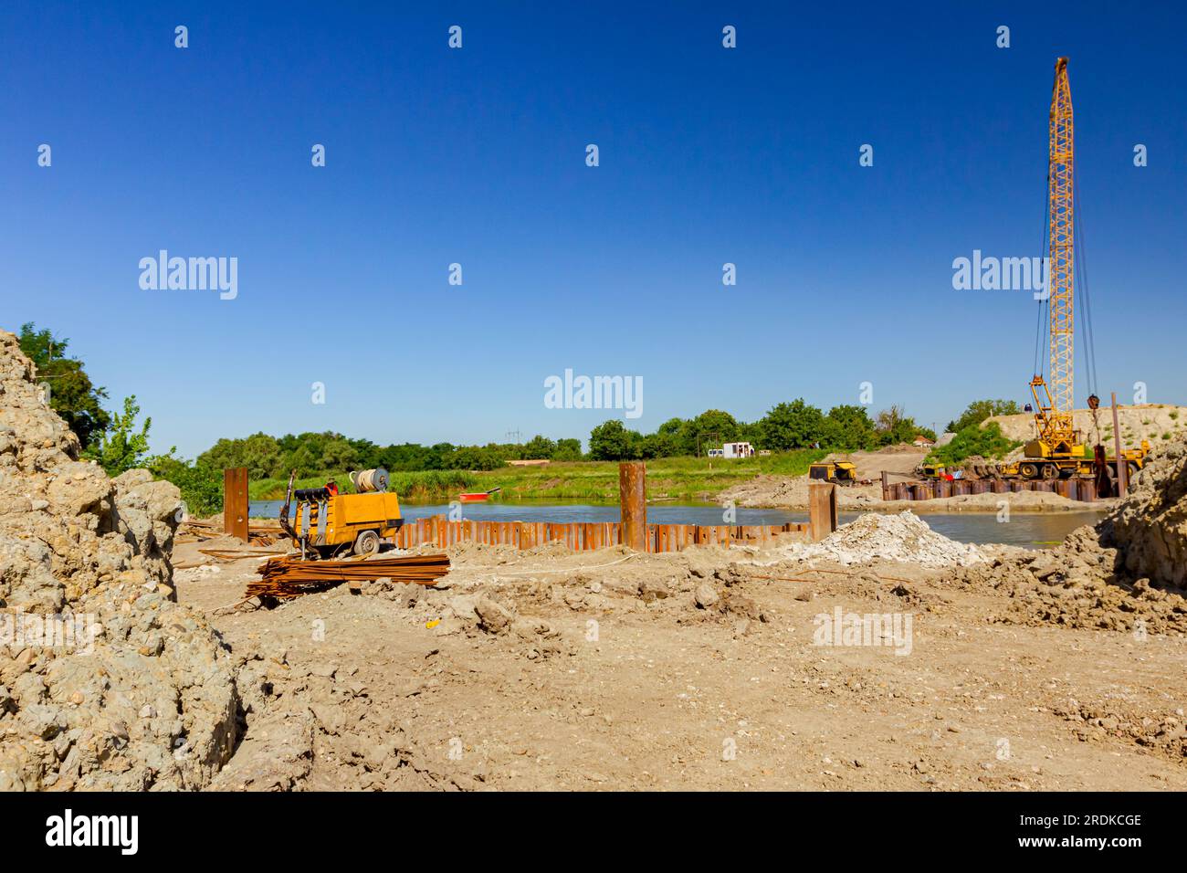 Installed metal piles along river bank, build in for bridge foundation ...