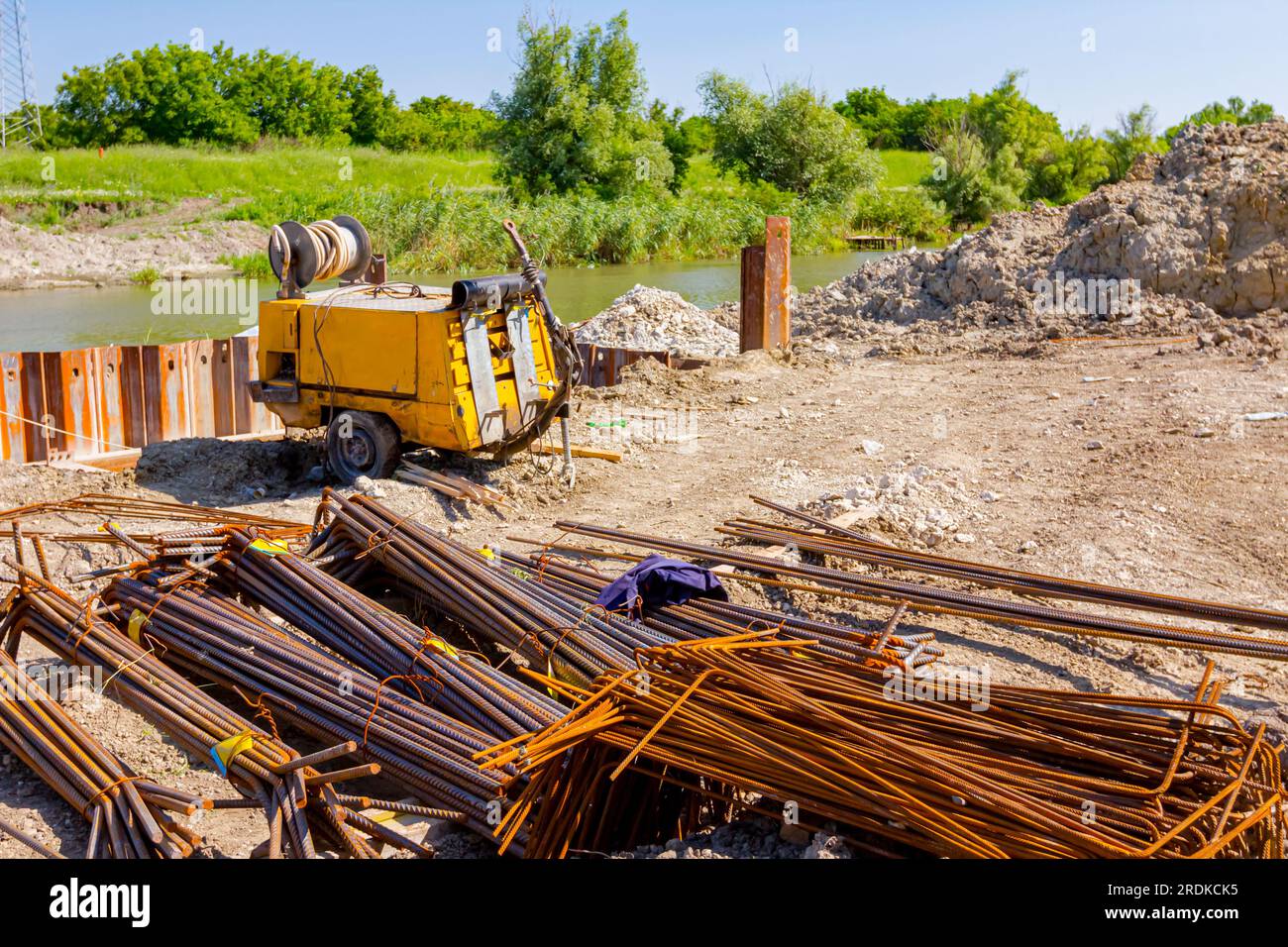 Installed metal piles along river bank, build in for bridge foundation ...
