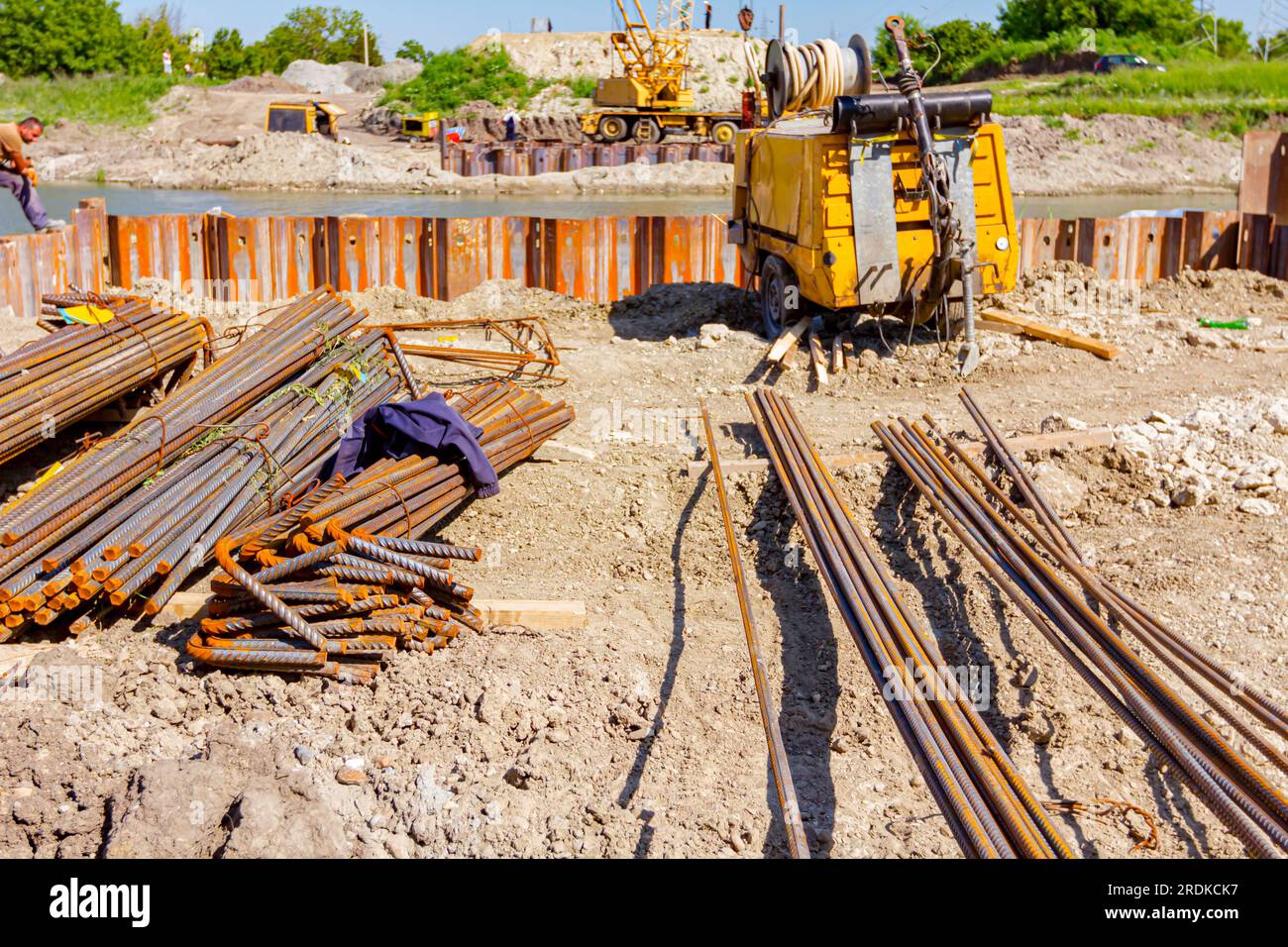 Selected tied bundles of reinforcement bars and yellow compressor ...