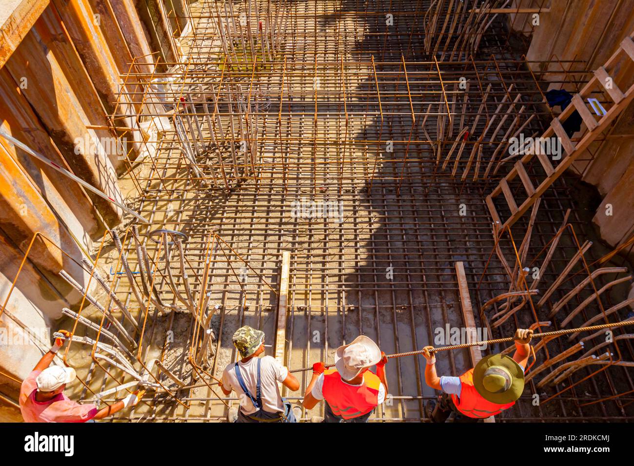 Shot above on workers surrounded by metal piles, who are installing ...