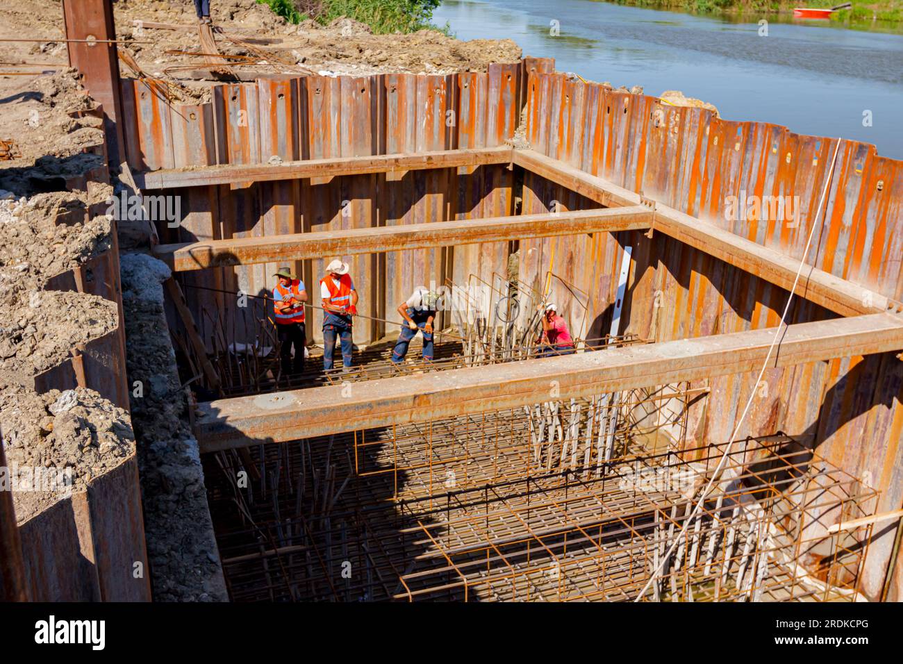 Shot above on workers surrounded by metal piles, who are installing ...